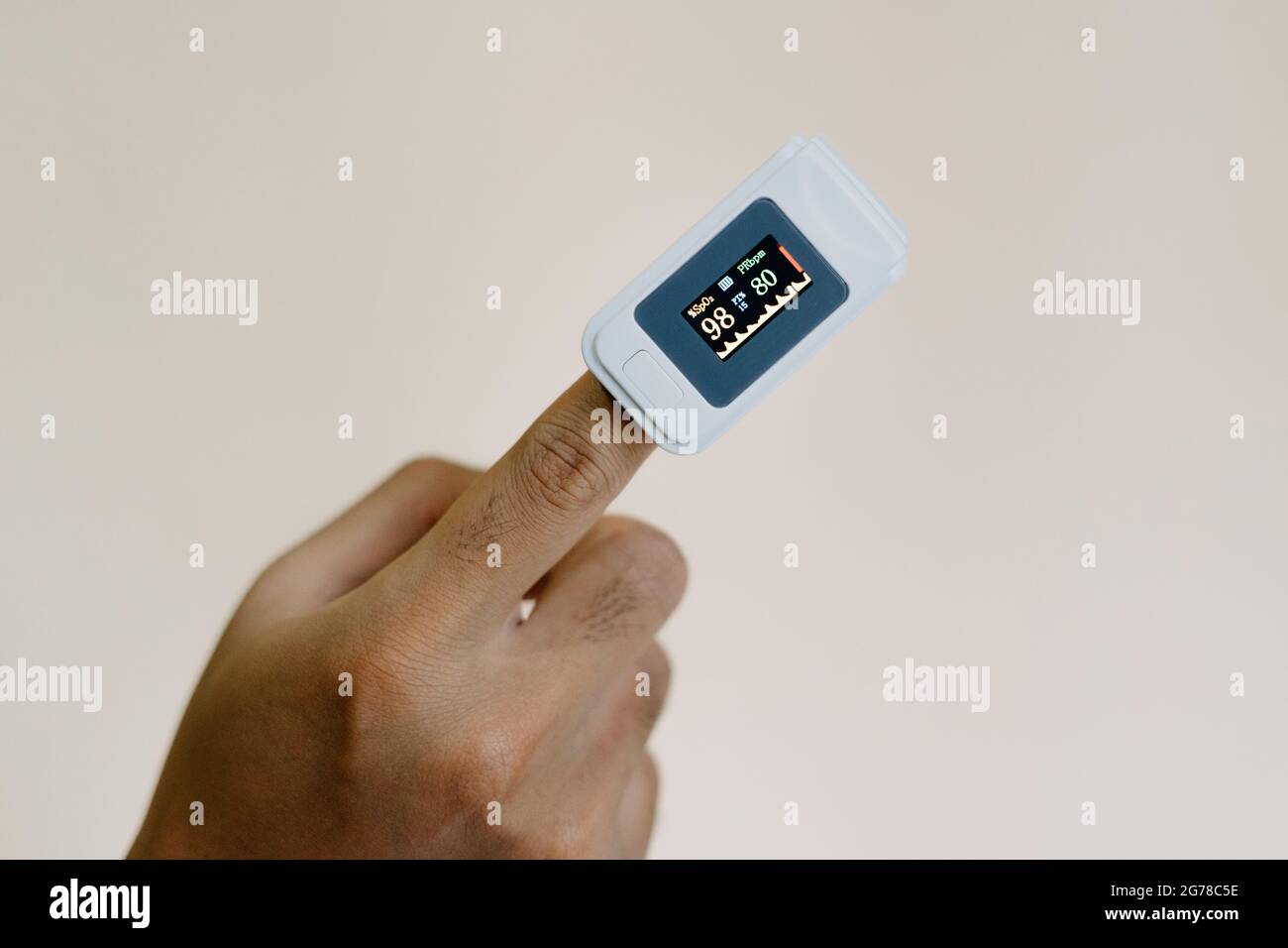 An index finger clamped with oximeter shows the oxygen saturation level ...