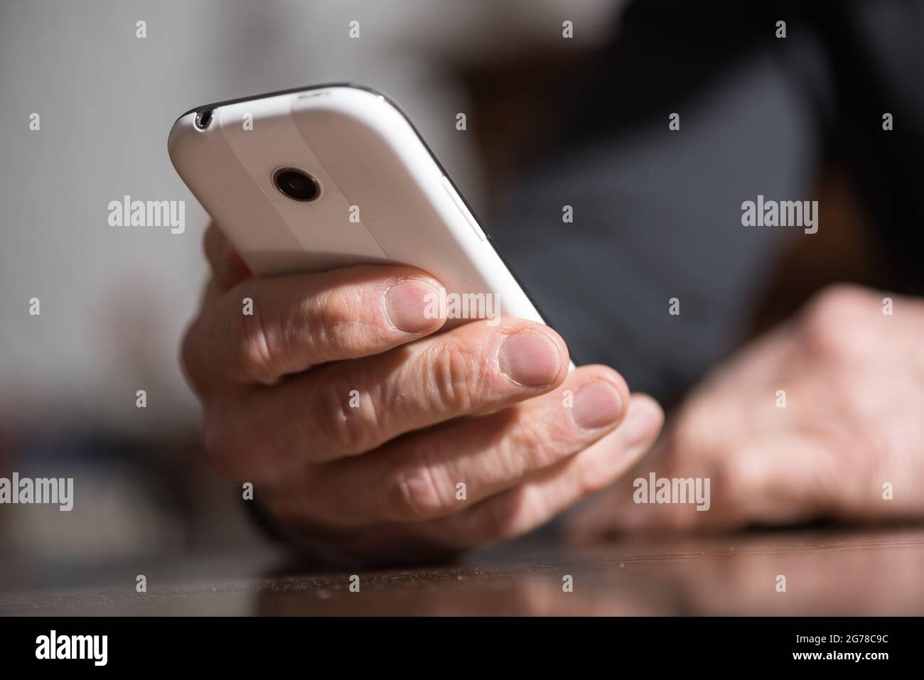 Hand holding a phone, closeup, hard light effect Stock Photo - Alamy