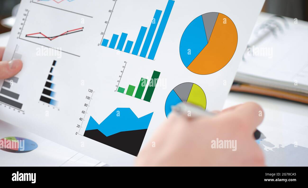 Hands holding a paper showing a graphical analysis concept Stock Photo ...