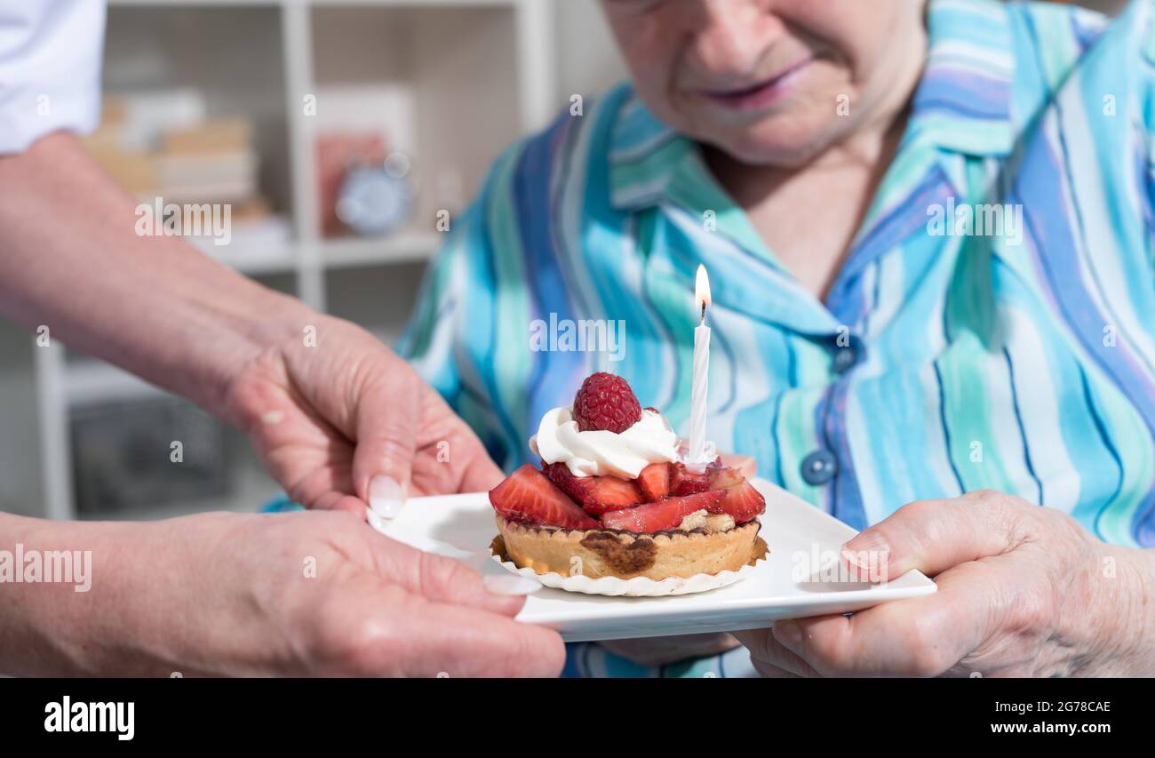 Old woman receiving a little birthday cake Stock Photo - Alamy
