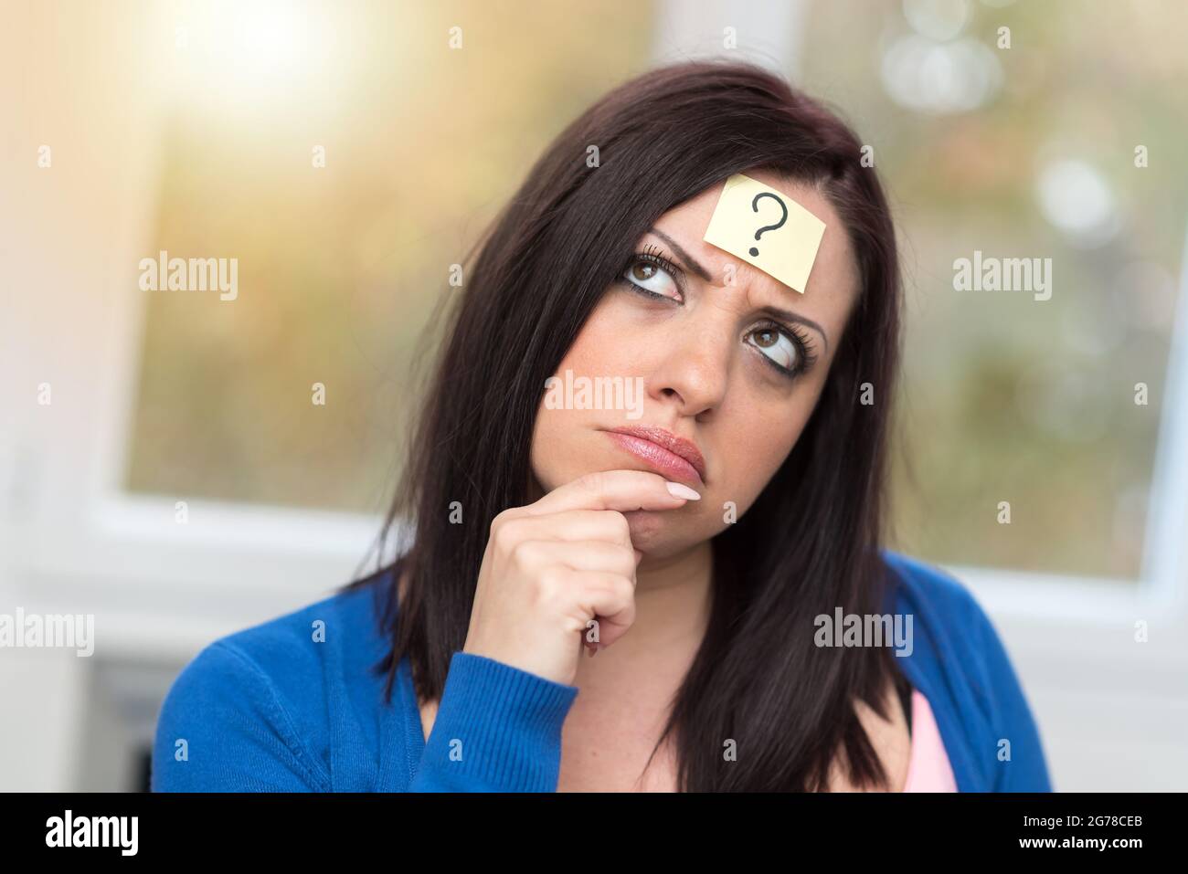 Thinking young woman with question mark on her forehead Stock Photo - Alamy