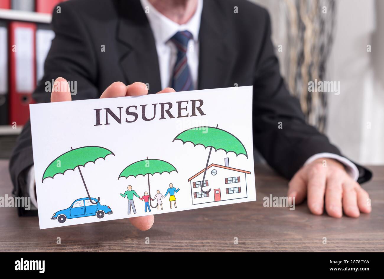 Insurer holding a card showing insurance concept Stock Photo - Alamy