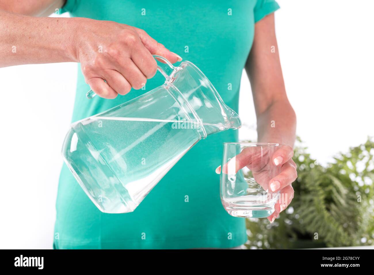 Woman pouring water from a pitcher into a glass Stock Photo - Alamy