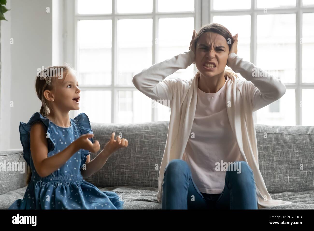 Angry young mom annoyed by noisy loud daughter Stock Photo - Alamy