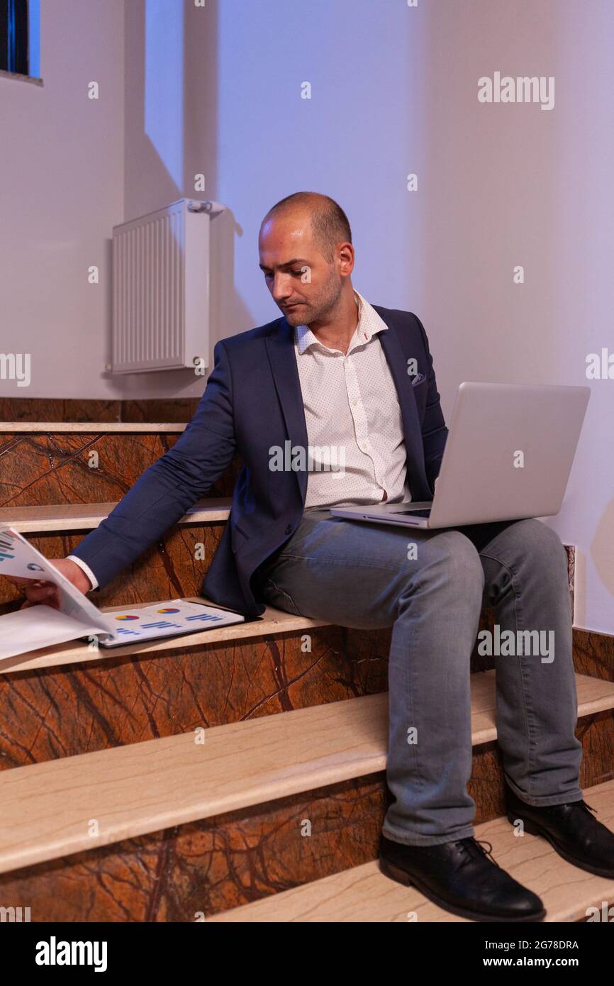 Tired overworked businessman working on deadline doing overtime late ...