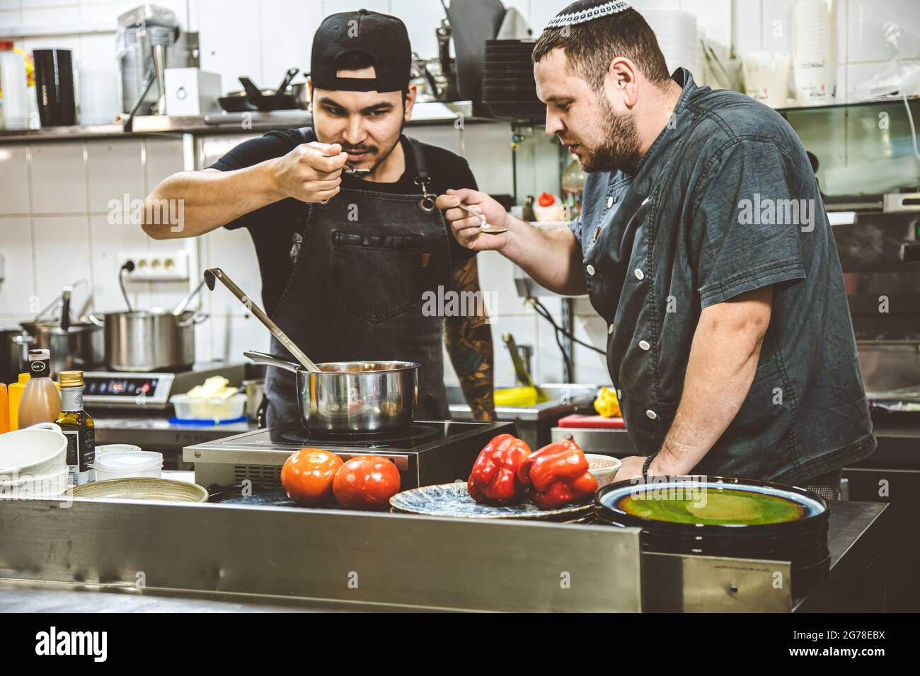 two chefs in the restaurant kitchen are trying food. training Stock ...