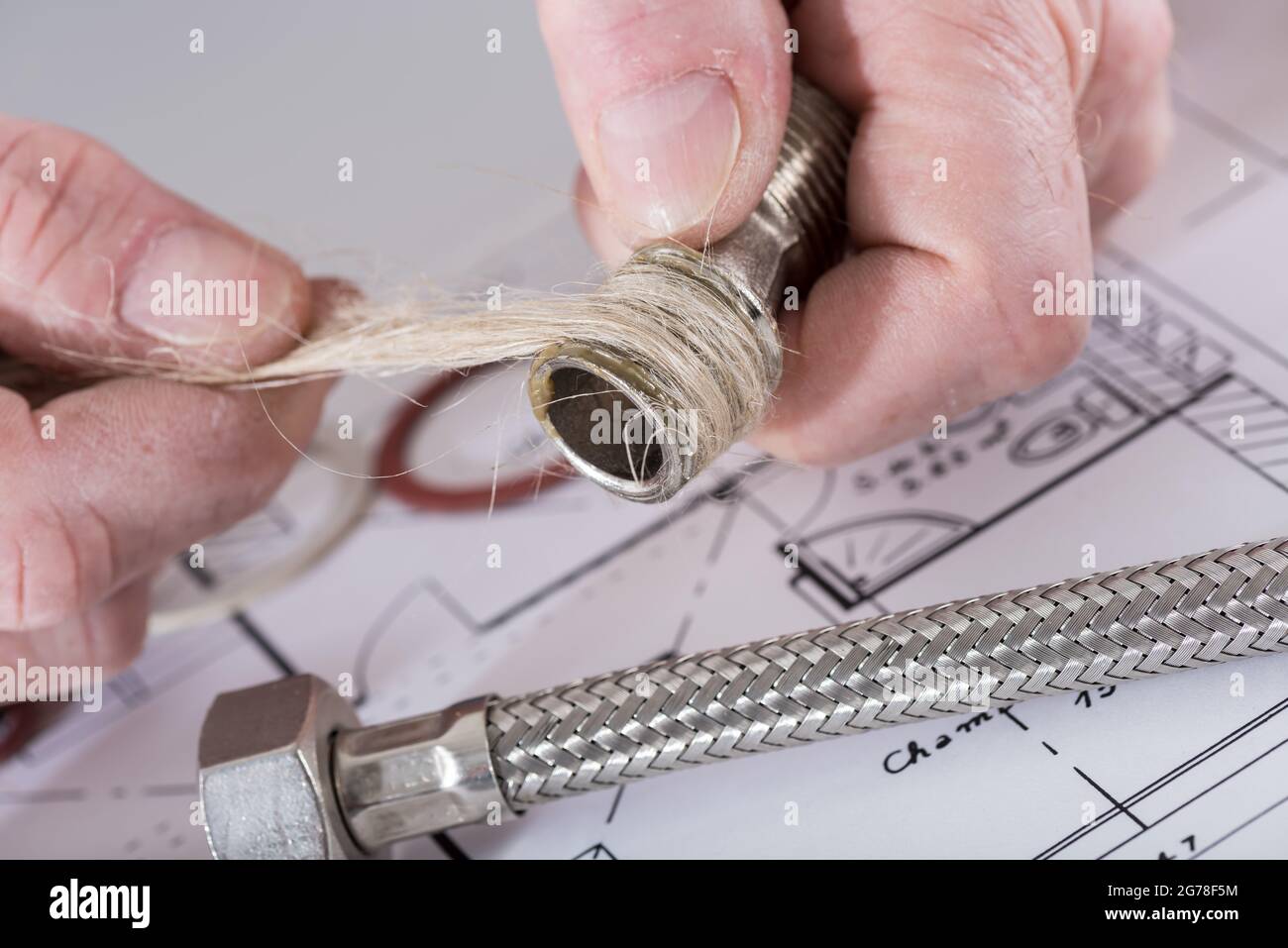 Plumber putting hemp fibers on a thread, closeup Stock Photo - Alamy