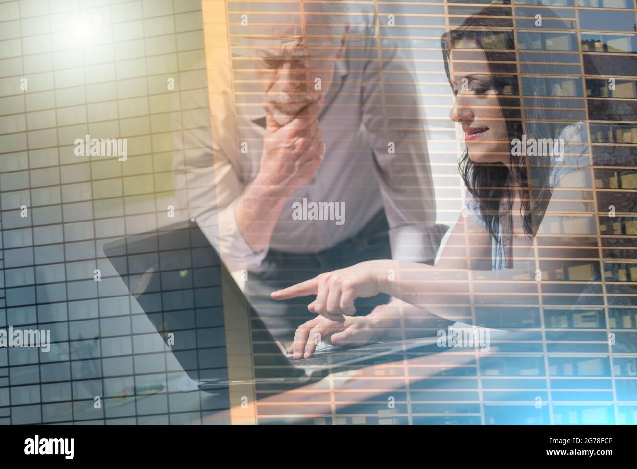 Young businesswoman and senior businessman working together at office ...