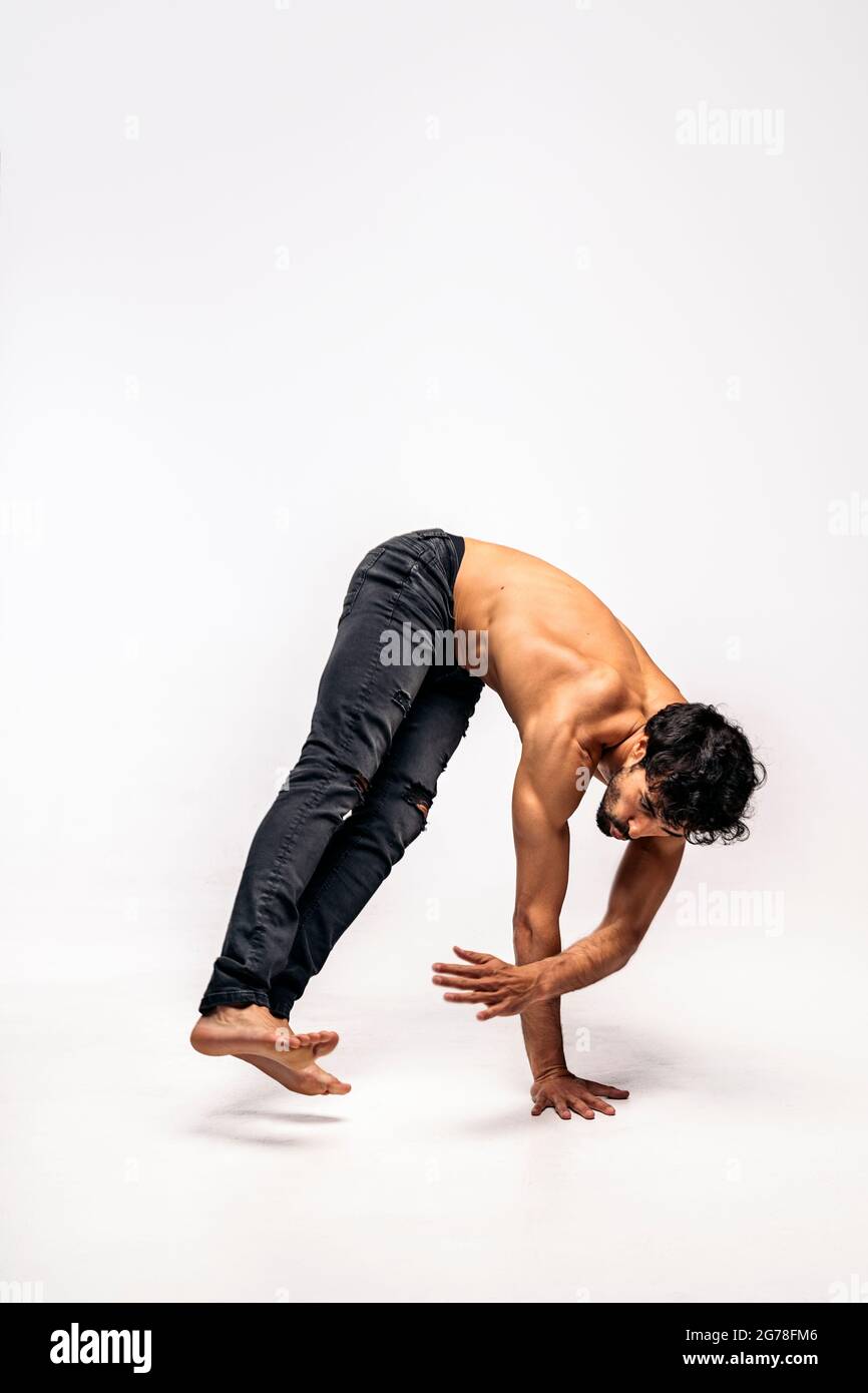 Hard-working dancer dancing in studio shot against white background. He ...