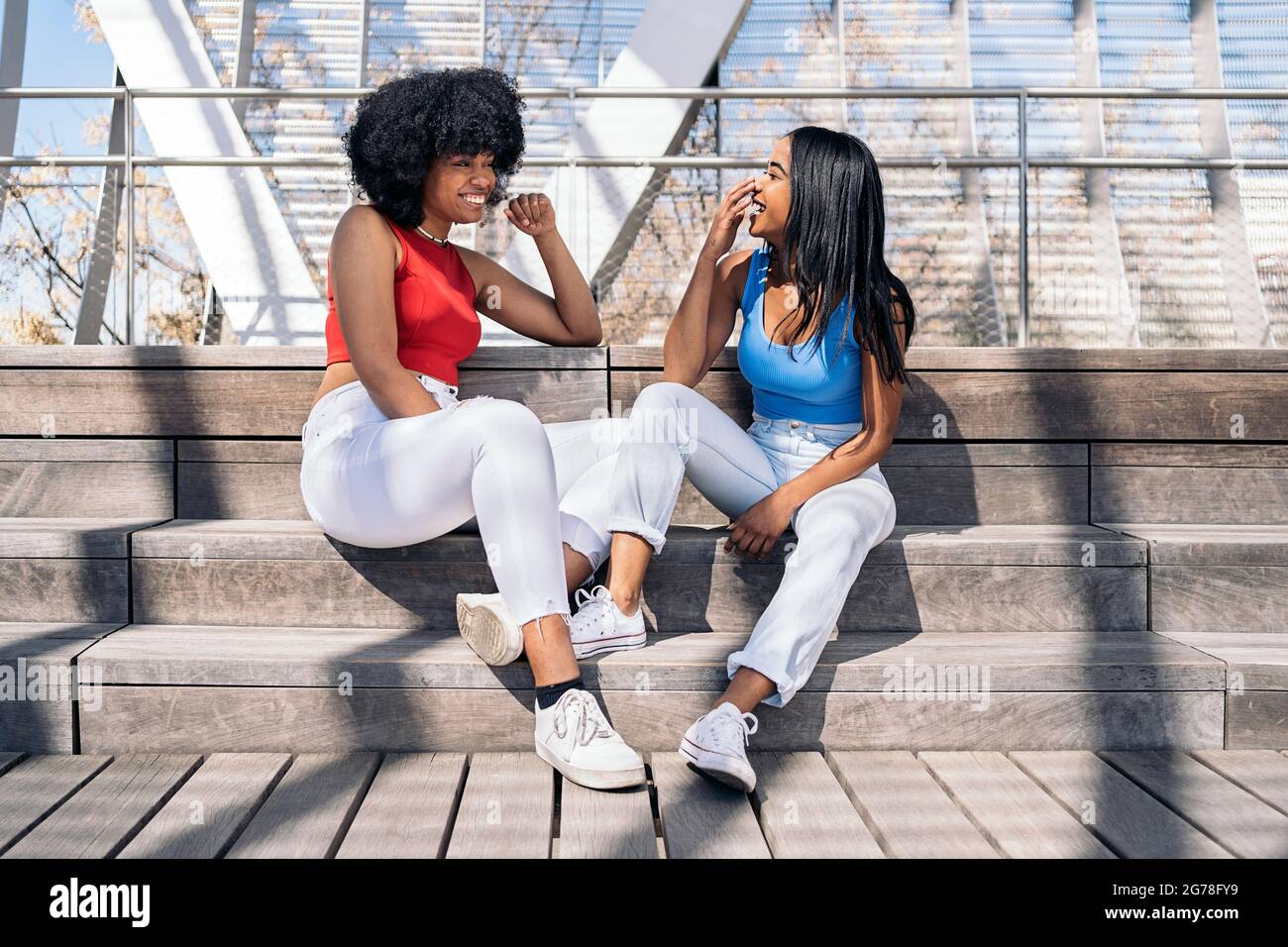 Pretty black female friends talking and laughing in the city. One of ...
