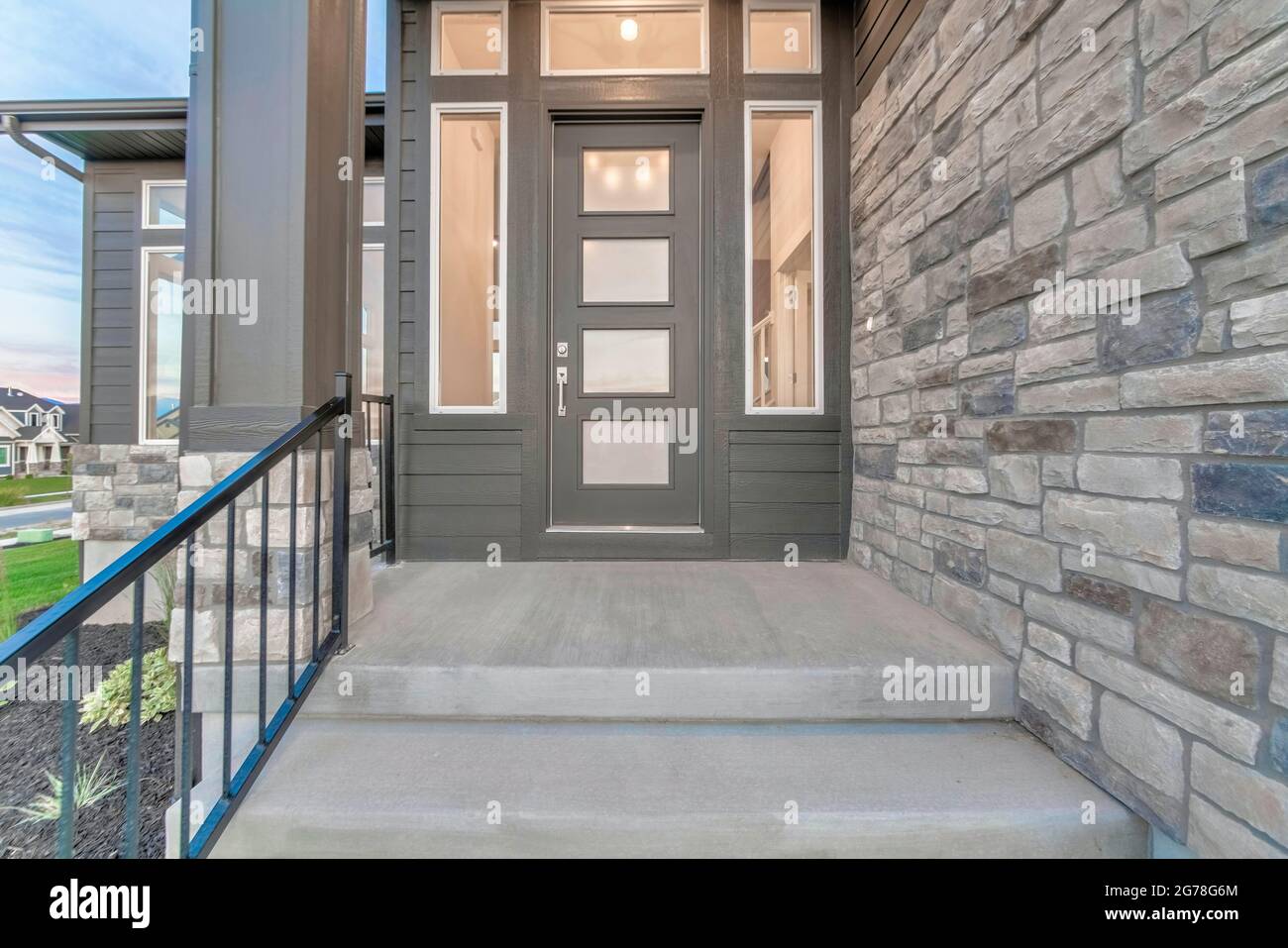 Front view of the house entrance with glass panelled front door and ...