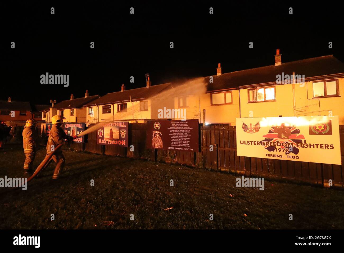 Fire fighters dampen down nearby properties as a huge bonfire in ...