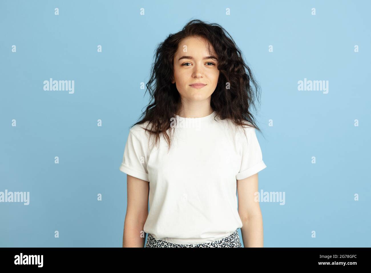 Portrait of young beautiful curly caucasian woman isolated over light ...
