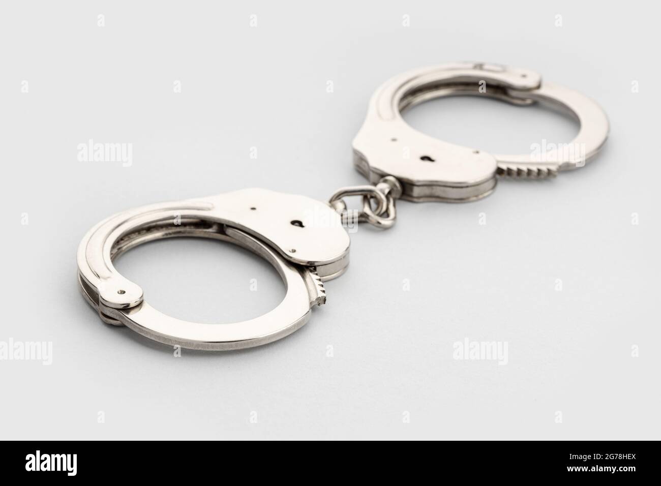 Metallic handcuffs isolated on gray background. Selective focus Stock ...