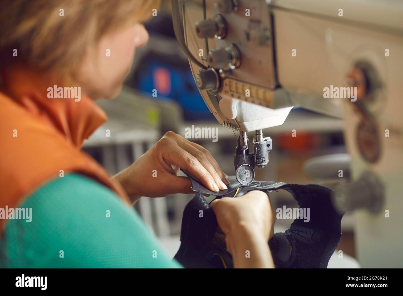 Shoemaker hands in focus sewing leather for making shoe using needle ...