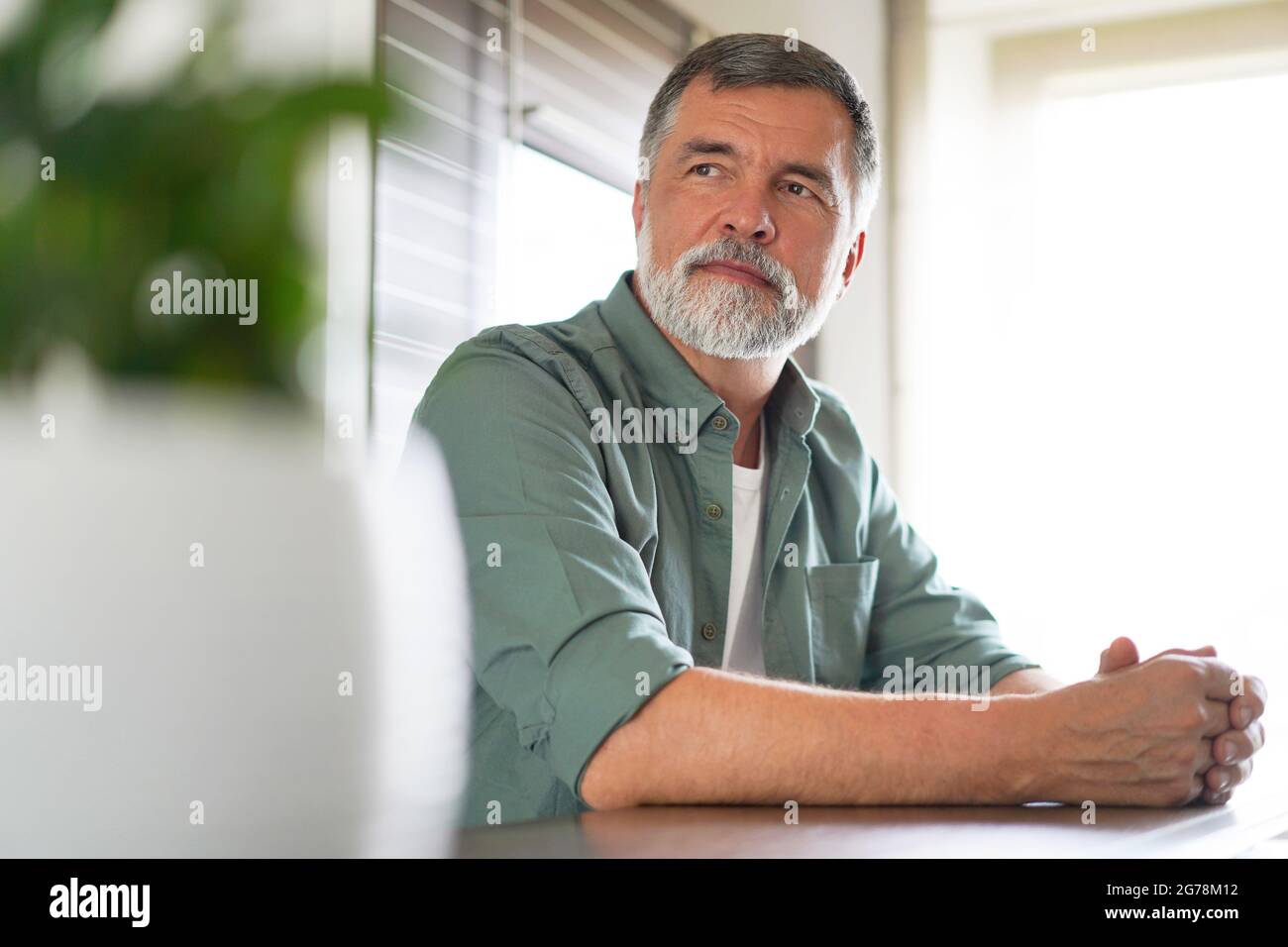 Mature happy man sitting table hi-res stock photography and images - Alamy