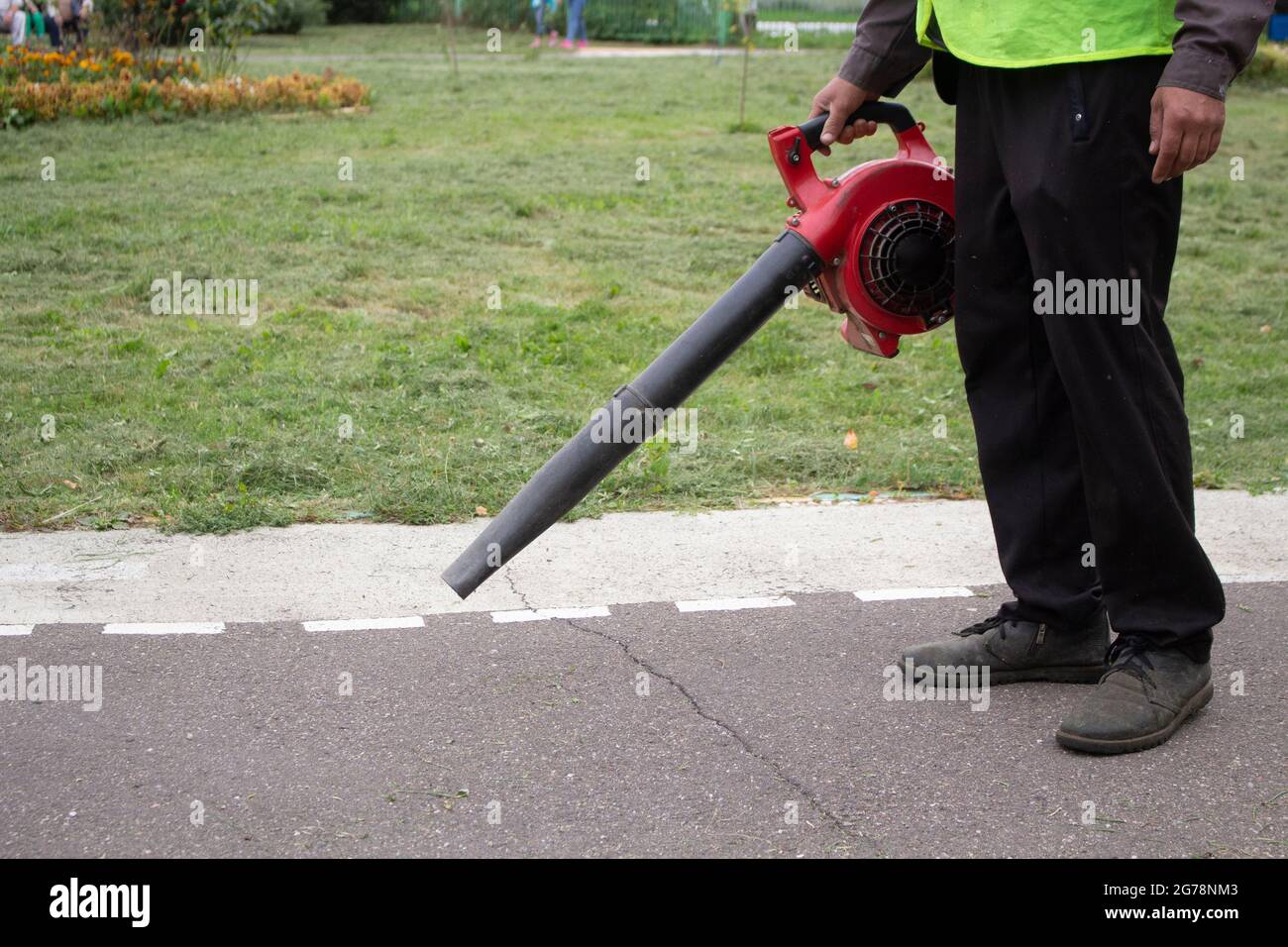 Gardener with a tool. Air turbine in the hand of a worker. Air flow ...