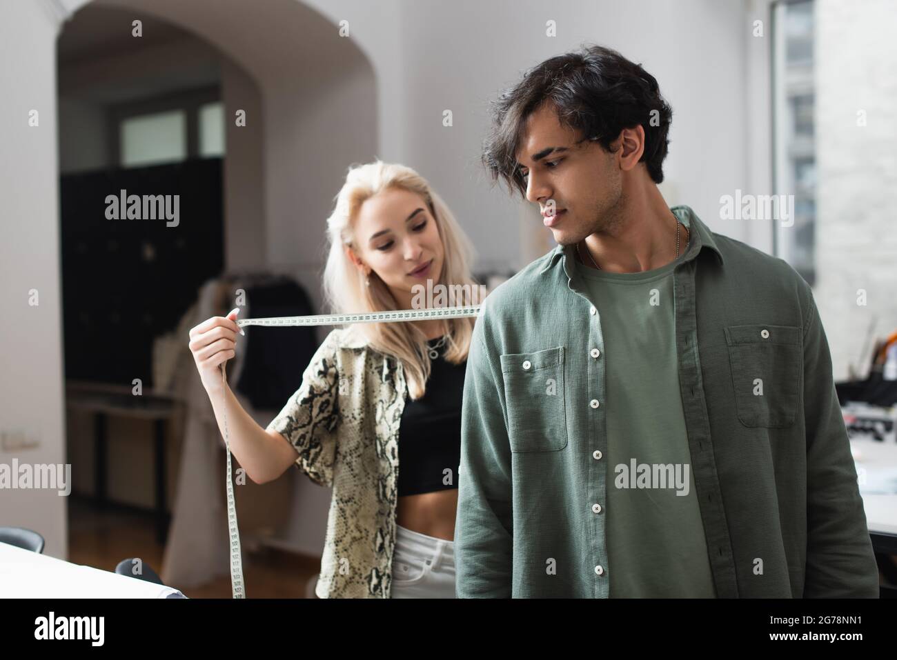 trendy designer measuring client in fashion atelier Stock Photo - Alamy