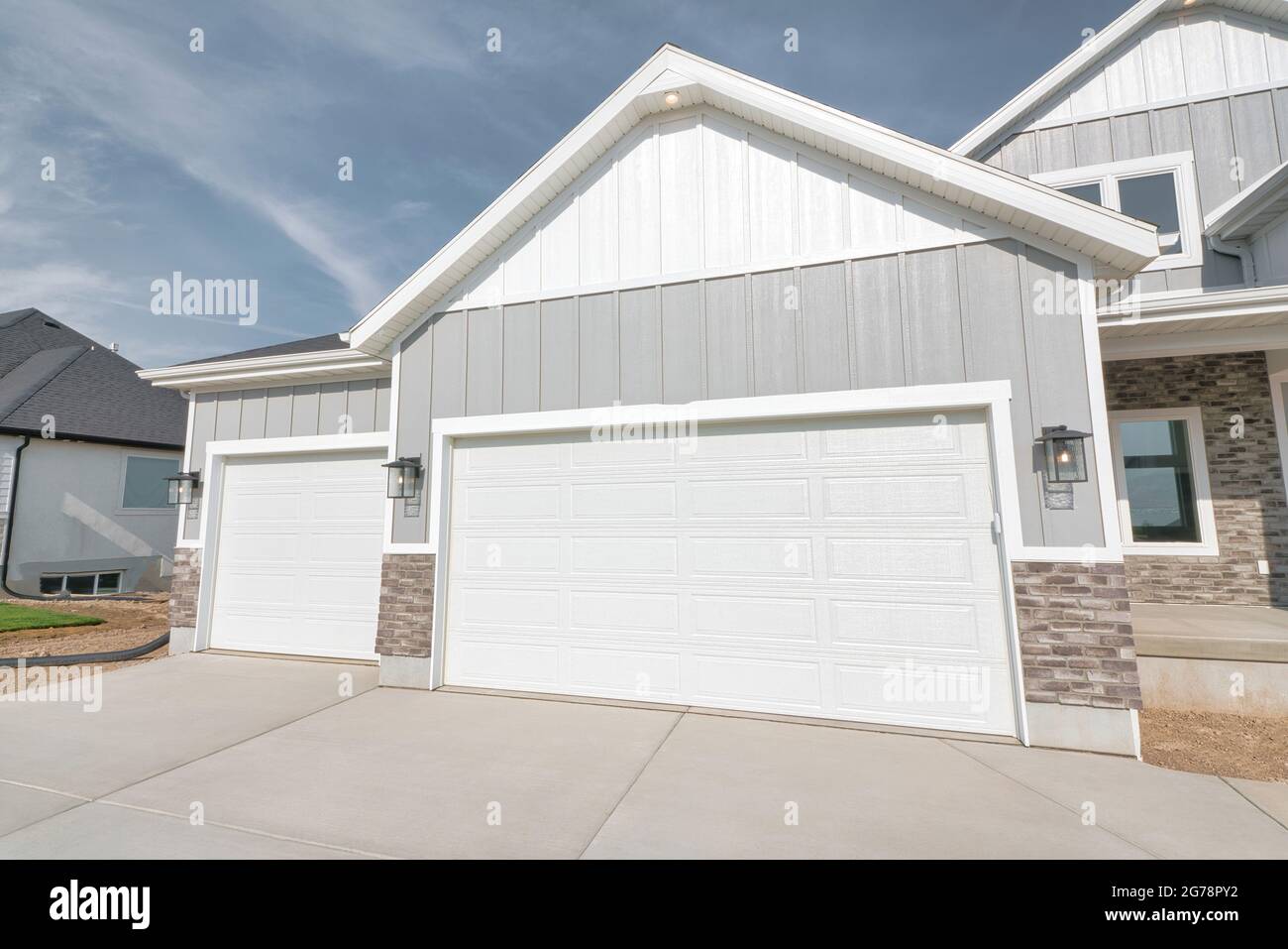 Entry to two car garage with white doors of house against blue sky ...