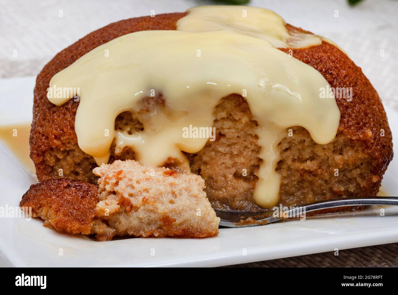 traditional South African Malva pudding served with custard Stock Photo ...