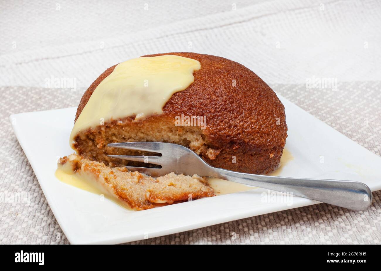 traditional South African Malva pudding served with custard Stock Photo ...