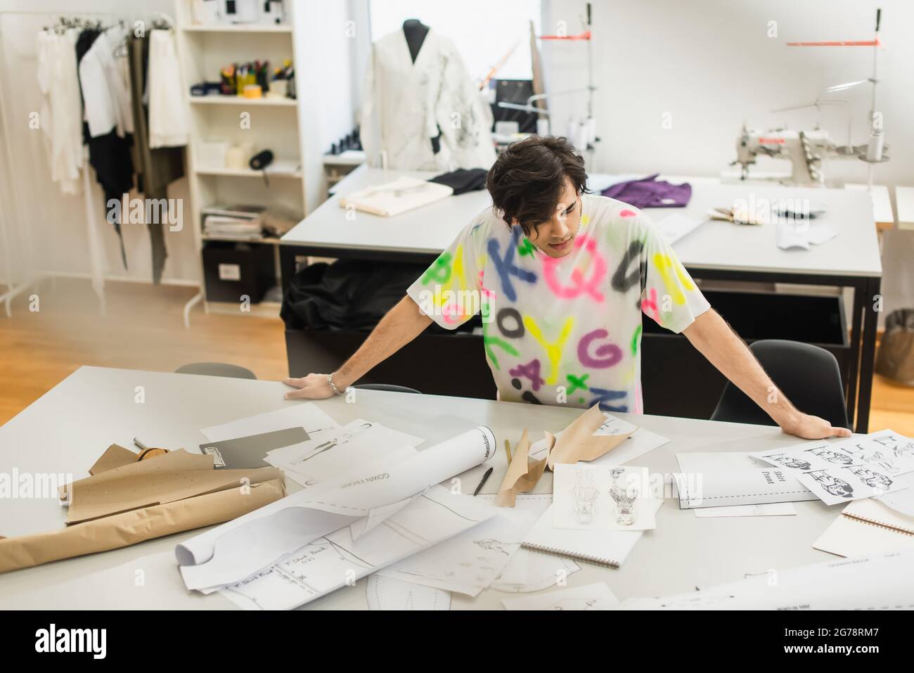 creative designer standing at workplace near sewing patterns and ...