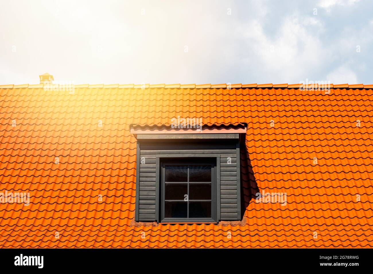 Renovated dormer window on the red clay ceramic tiles roof. Bright ...