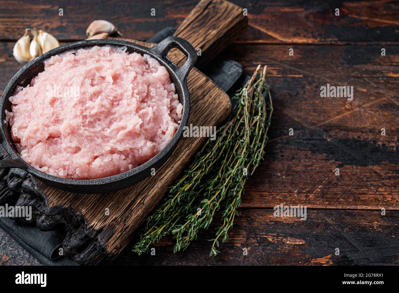 Uncooked Raw minced chicken and turkey meat in a pan with herbs. Dark ...
