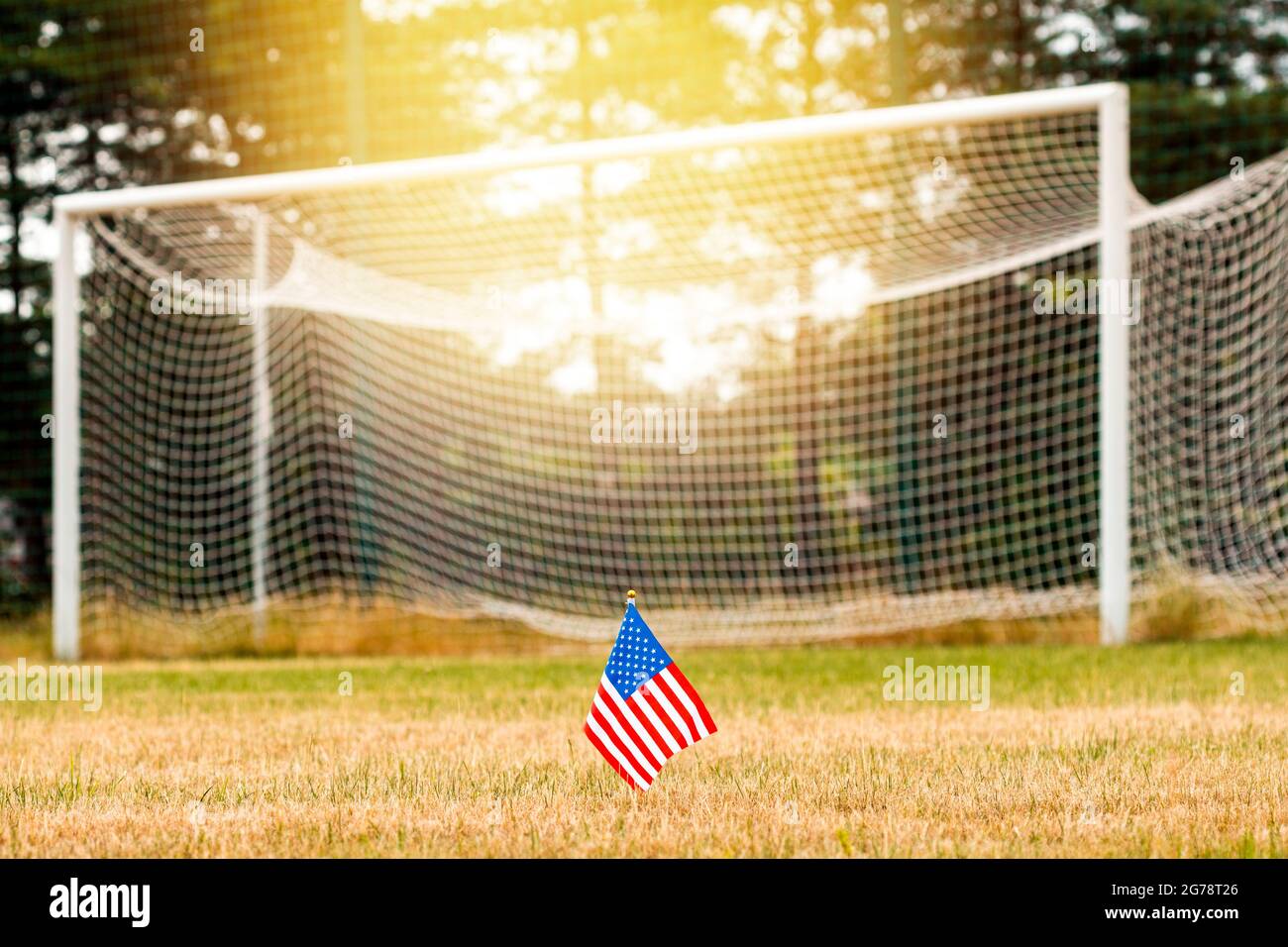 USA flag on a soccer field with empty gates on background. National ...