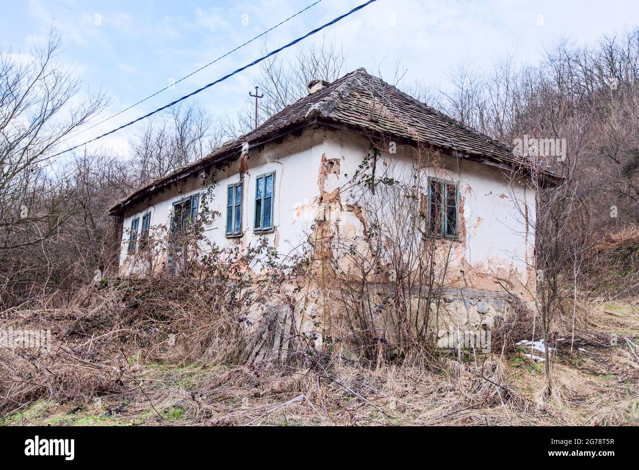 Deserted, weathered house in a rural landscape stands as a reminder of ...