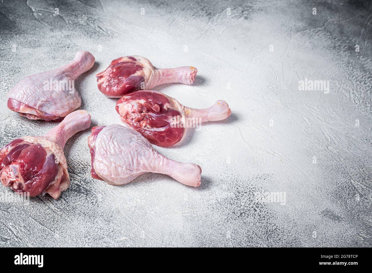 Raw Duck legs drumsticks on butcher table. White background. Top view ...