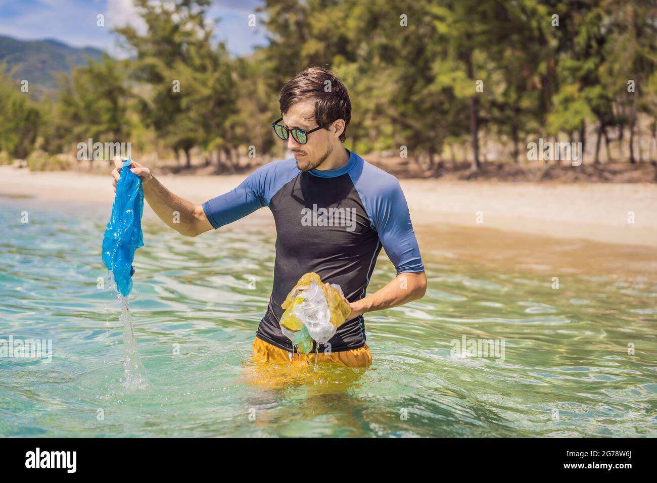 Man collects packages from the beautiful turquoise sea. Paradise beach ...
