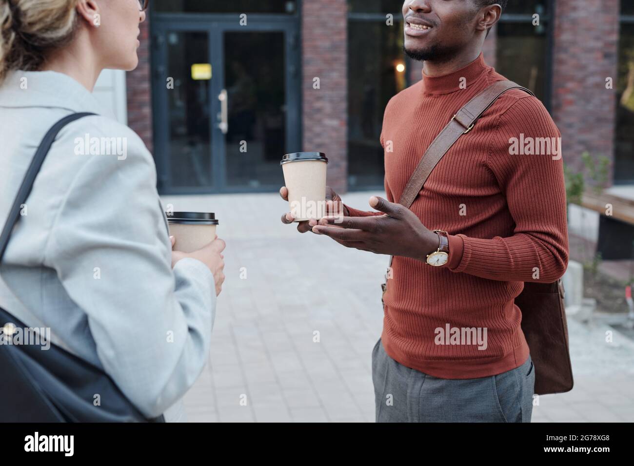 African man and Caucasian woman with drinks talking at coffee break in ...