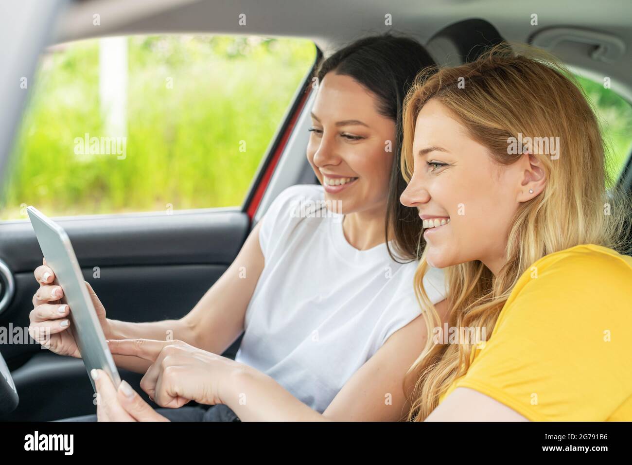 Young women in the car use the tablet Stock Photo - Alamy