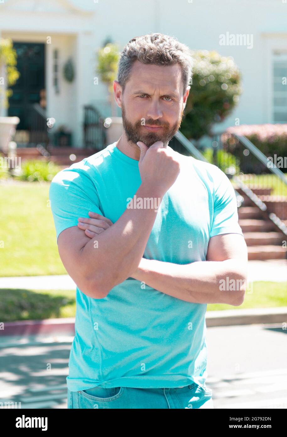 serious charismatic unshaven man touch his beard, male charisma Stock ...