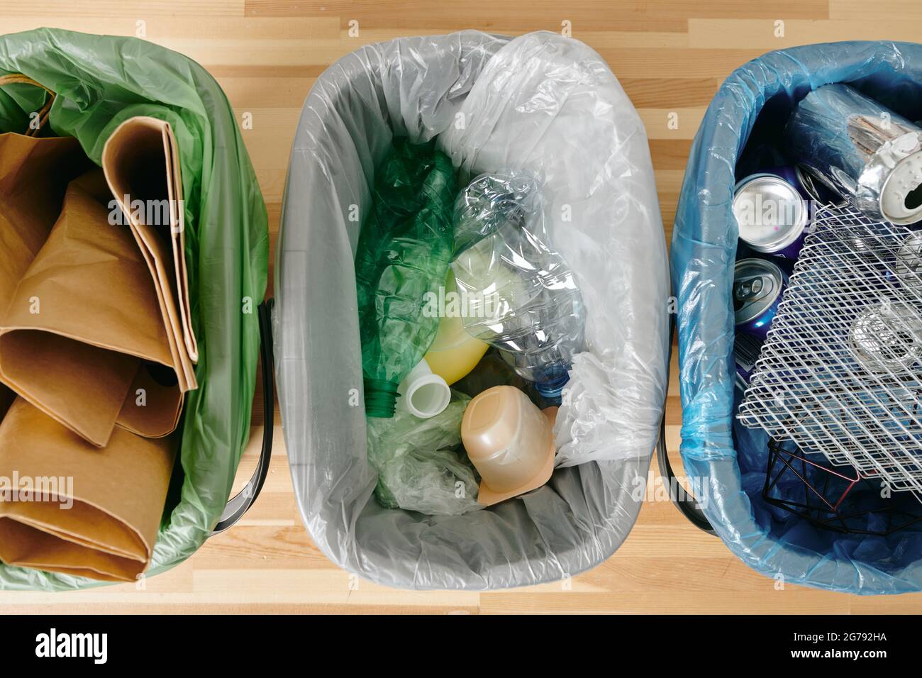 View of three containers with recyclable garbage on table Stock Photo ...