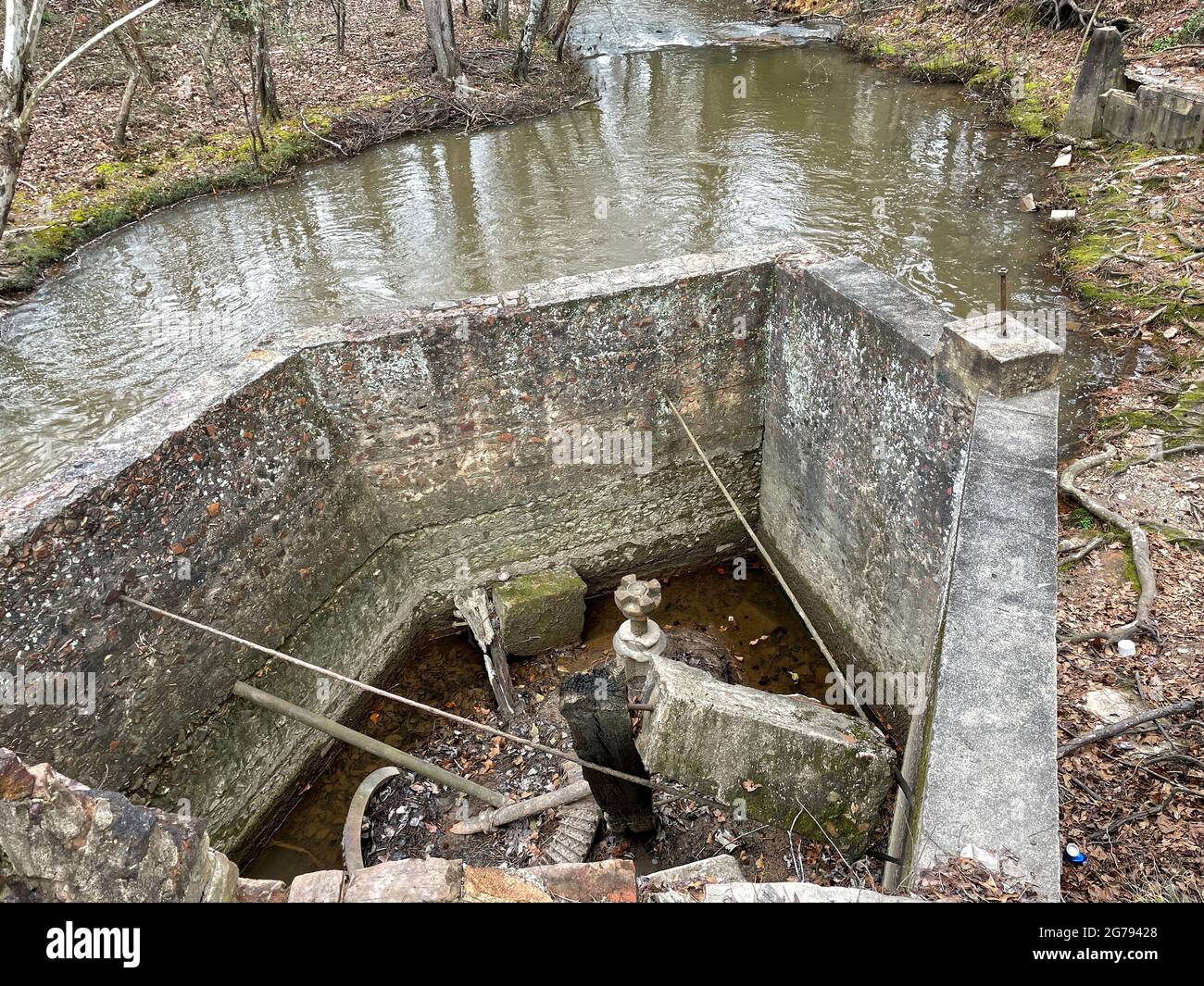 Dam concrete wall and valves with fall foliage in a forest in rural ...