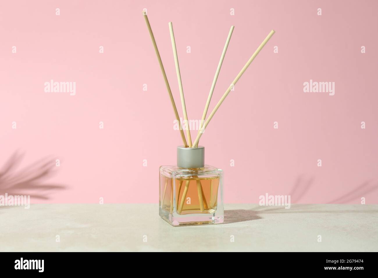 Diffuser bottle with sticks against pink background Stock Photo - Alamy