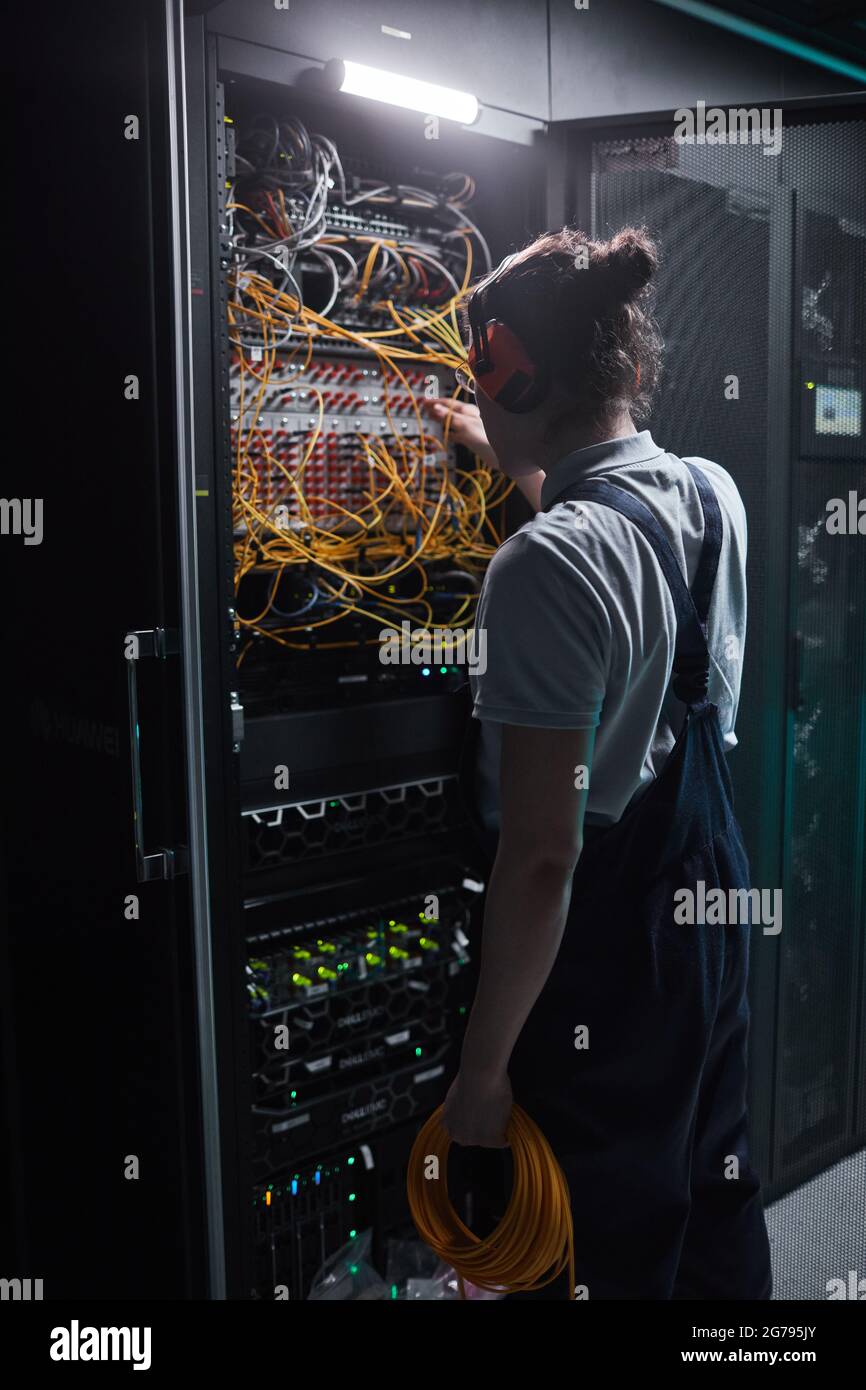 Vertical back view of network engineer in server room during ...