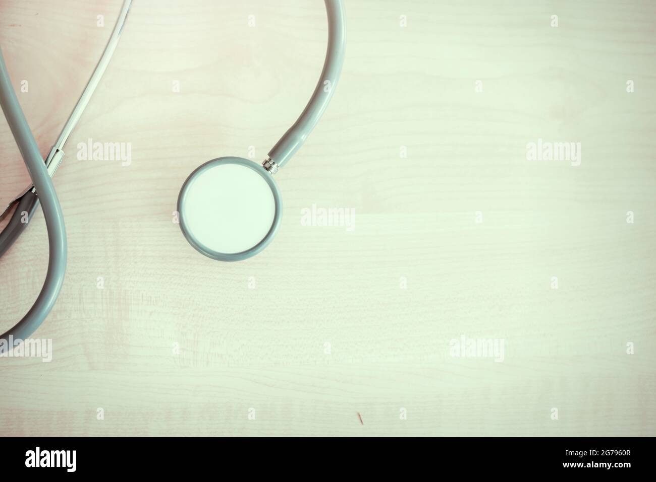 Gray Medical stethoscope on wooden background.Cross processing and ...