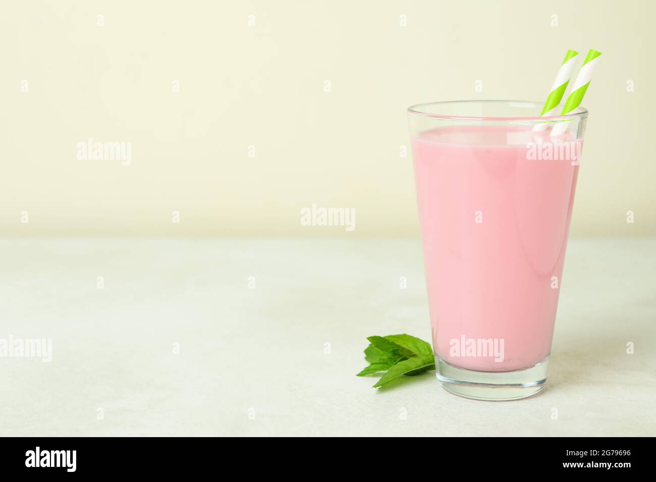 Glass of strawberry milkshake on white textured table Stock Photo - Alamy