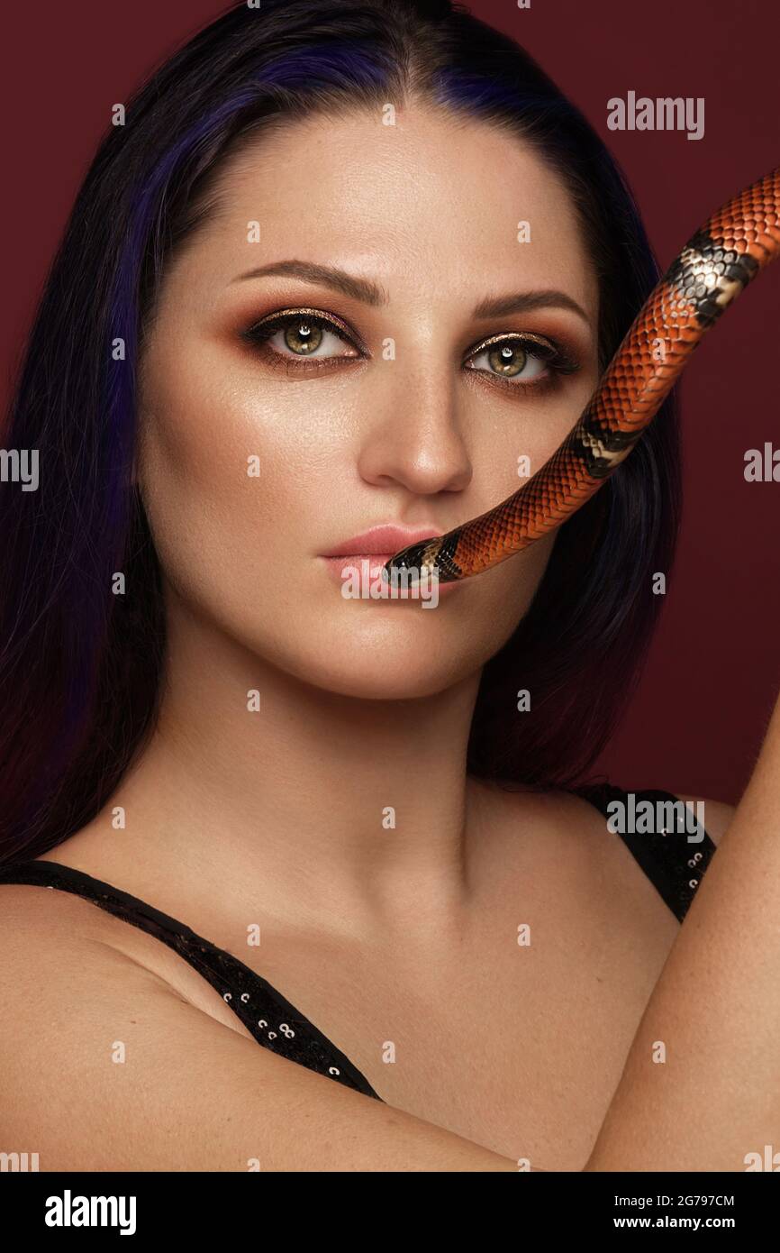 Beautiful girl brunette model with evening fashion make-up with a snake ...