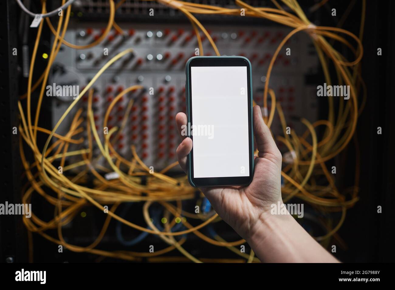 Close up of network engineer holding smartphone with blank screen in ...