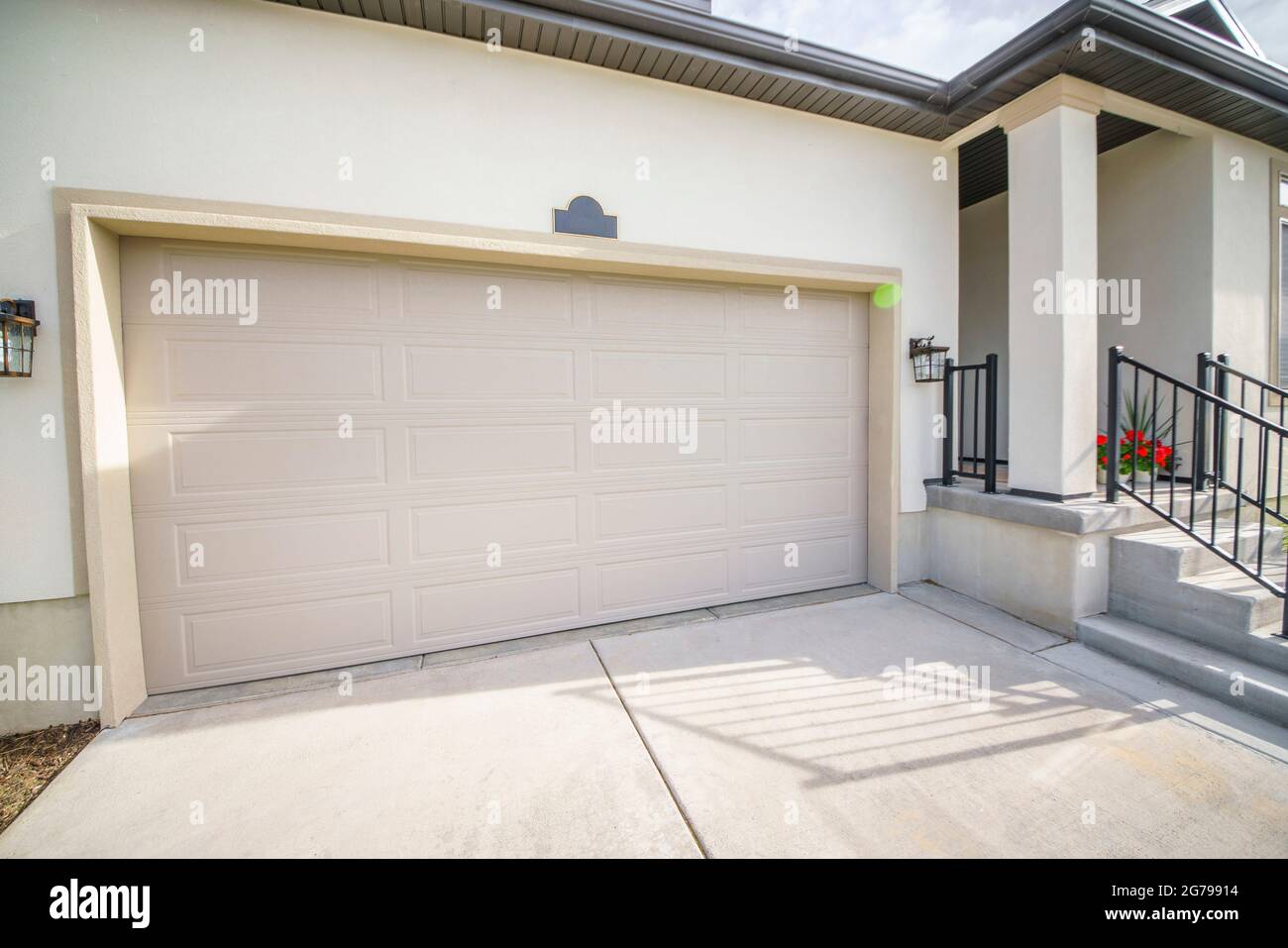 Exterior of a house with closed garage door and part of a porch entry ...