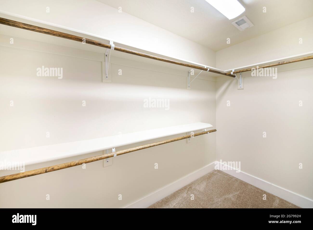 Empty walk-in closet with white walls and carpeted floor Stock Photo ...