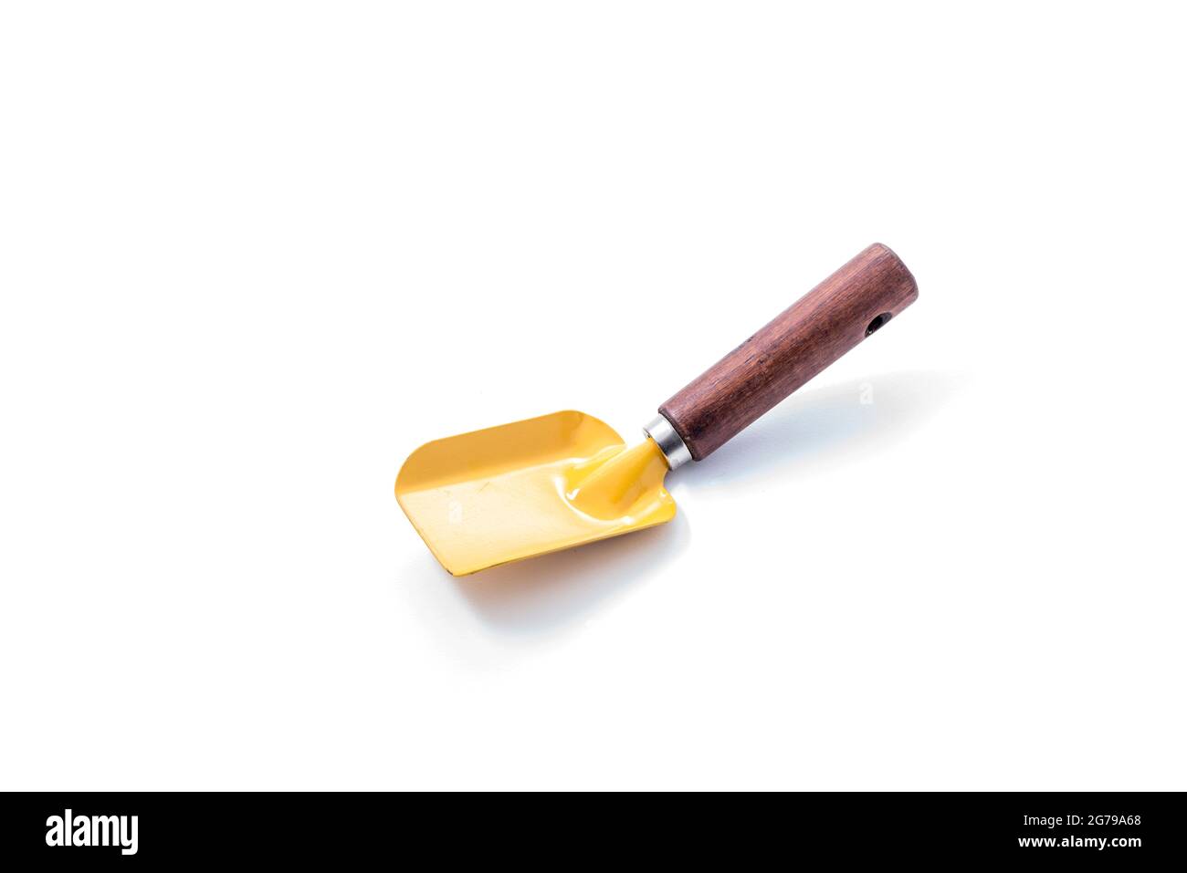 Mini yellow shovel with wooden handle isolated on white background ...