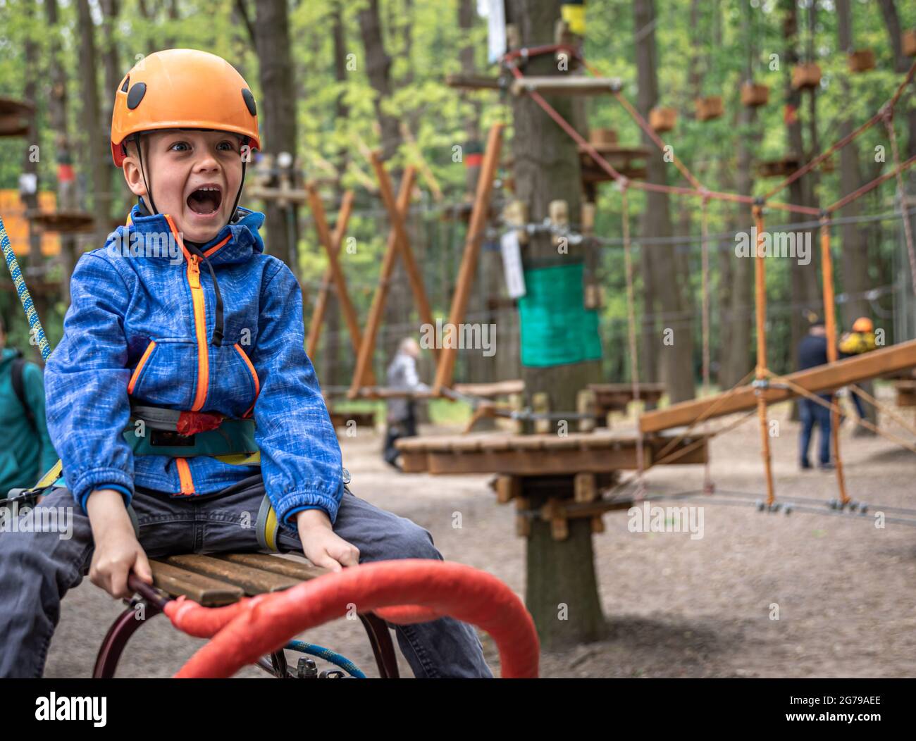 Adventure climbing high wire park - little boy on course in helmet and ...