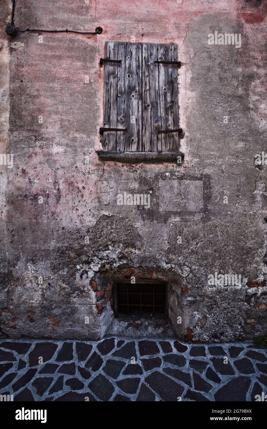 Modern pavement made of stone slabs in front of an old house wall with ...