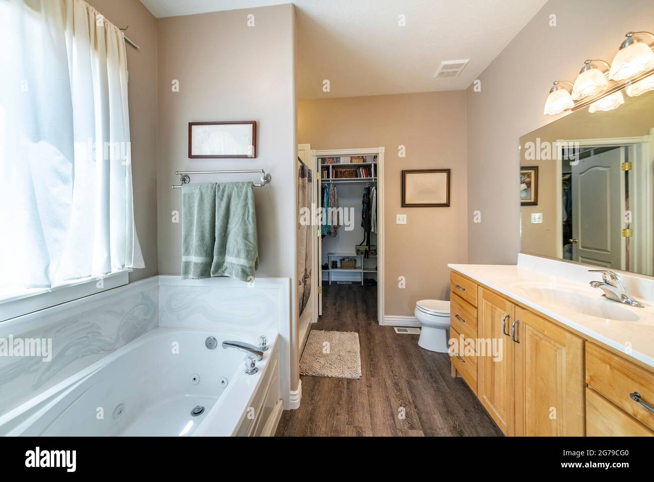 Large bathroom with walk-in closet and long vanity sink Stock Photo - Alamy