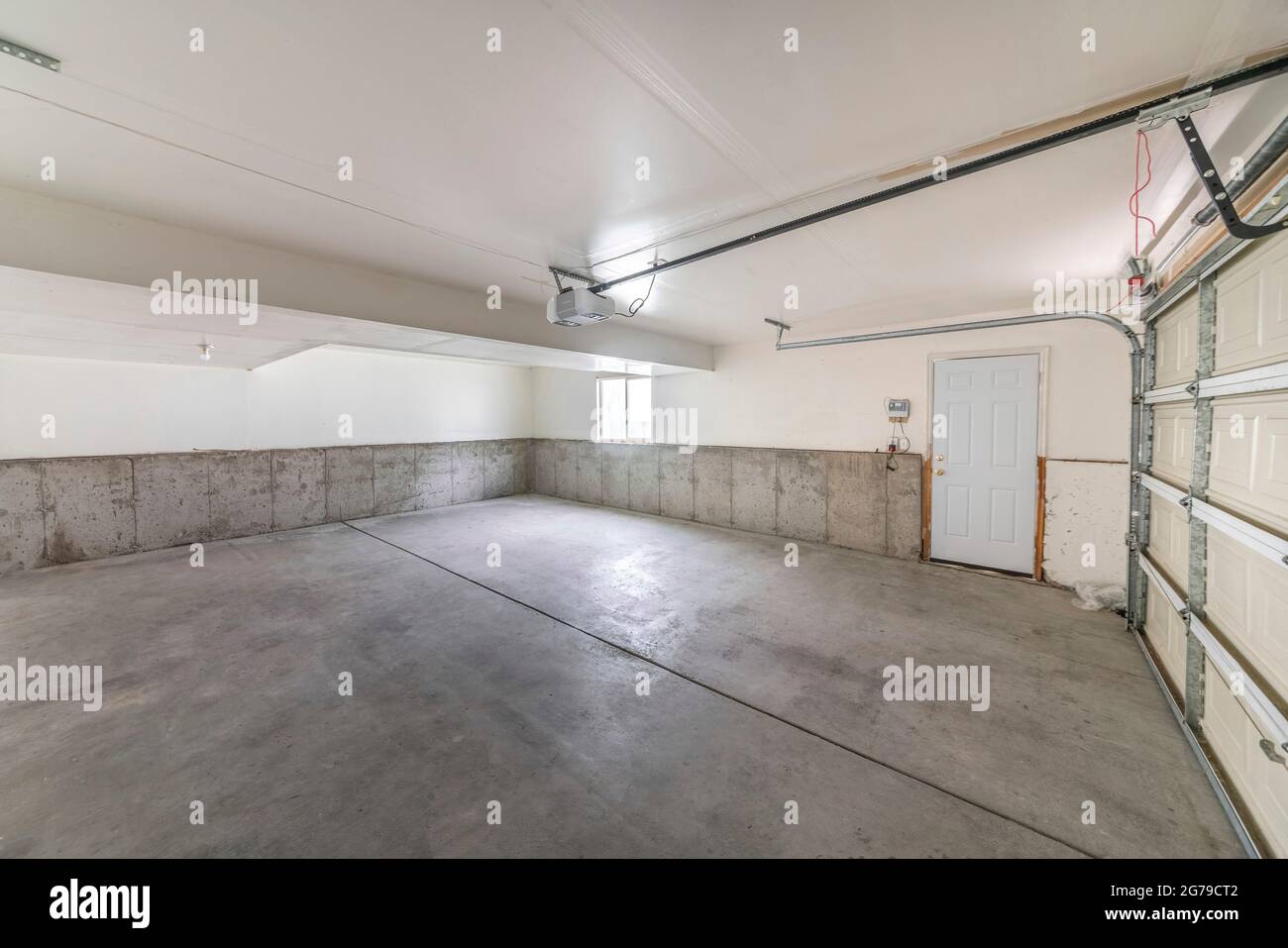 Empty garage interior with concrete floors and an automatic door Stock ...